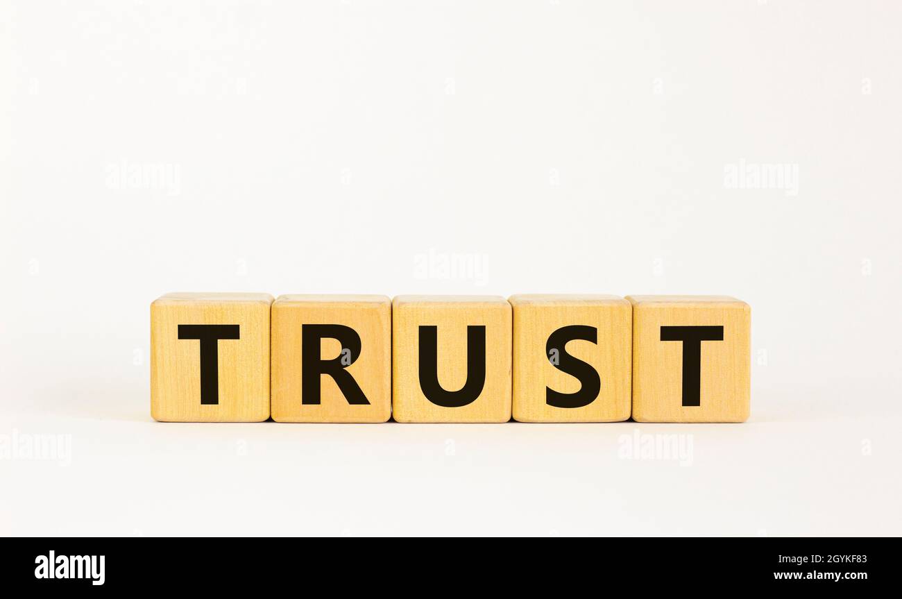Trust symbol. The concept word 'trust' on wooden cubes. Beautiful white ...