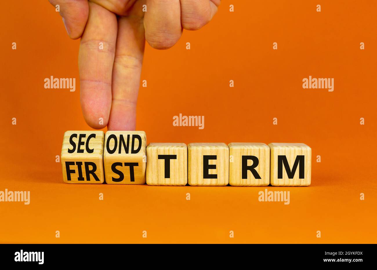 First or second term symbol. Businessman turns wooden cubes, changes ...