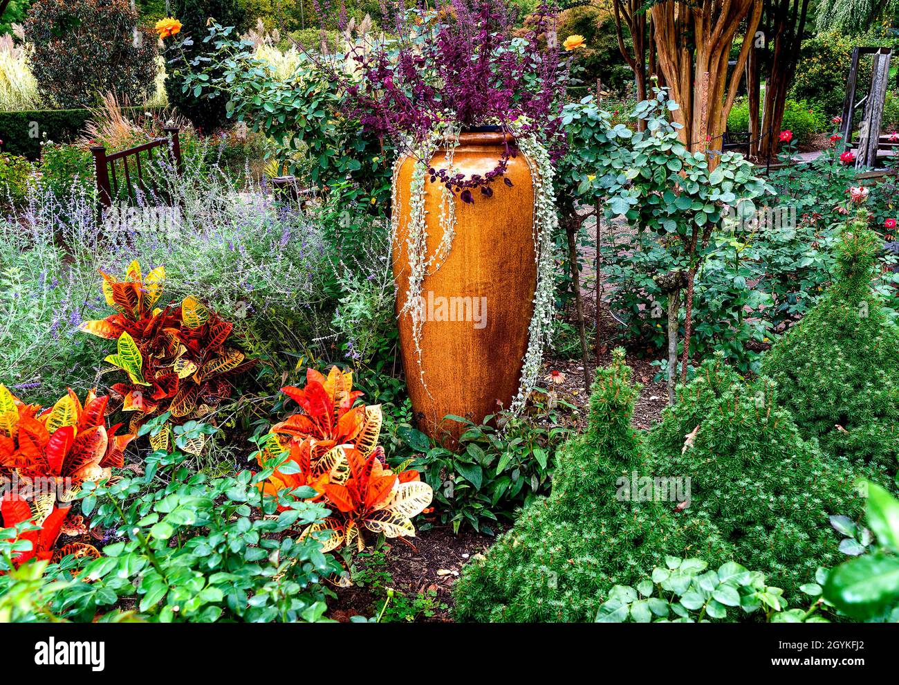 Urn at the centre of a garden floral display Stock Photo - Alamy