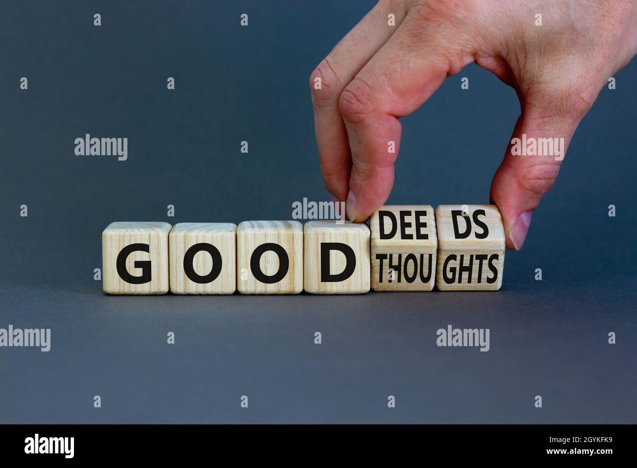 Good thoughts and deeds symbol. Businessman turns wooden cubes and ...