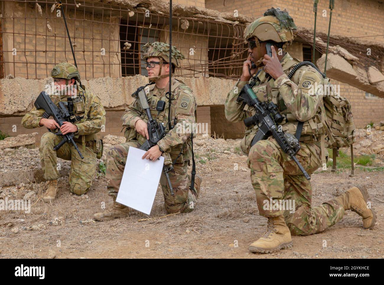Coalition soldiers conduct a radio status check during a base defense ...