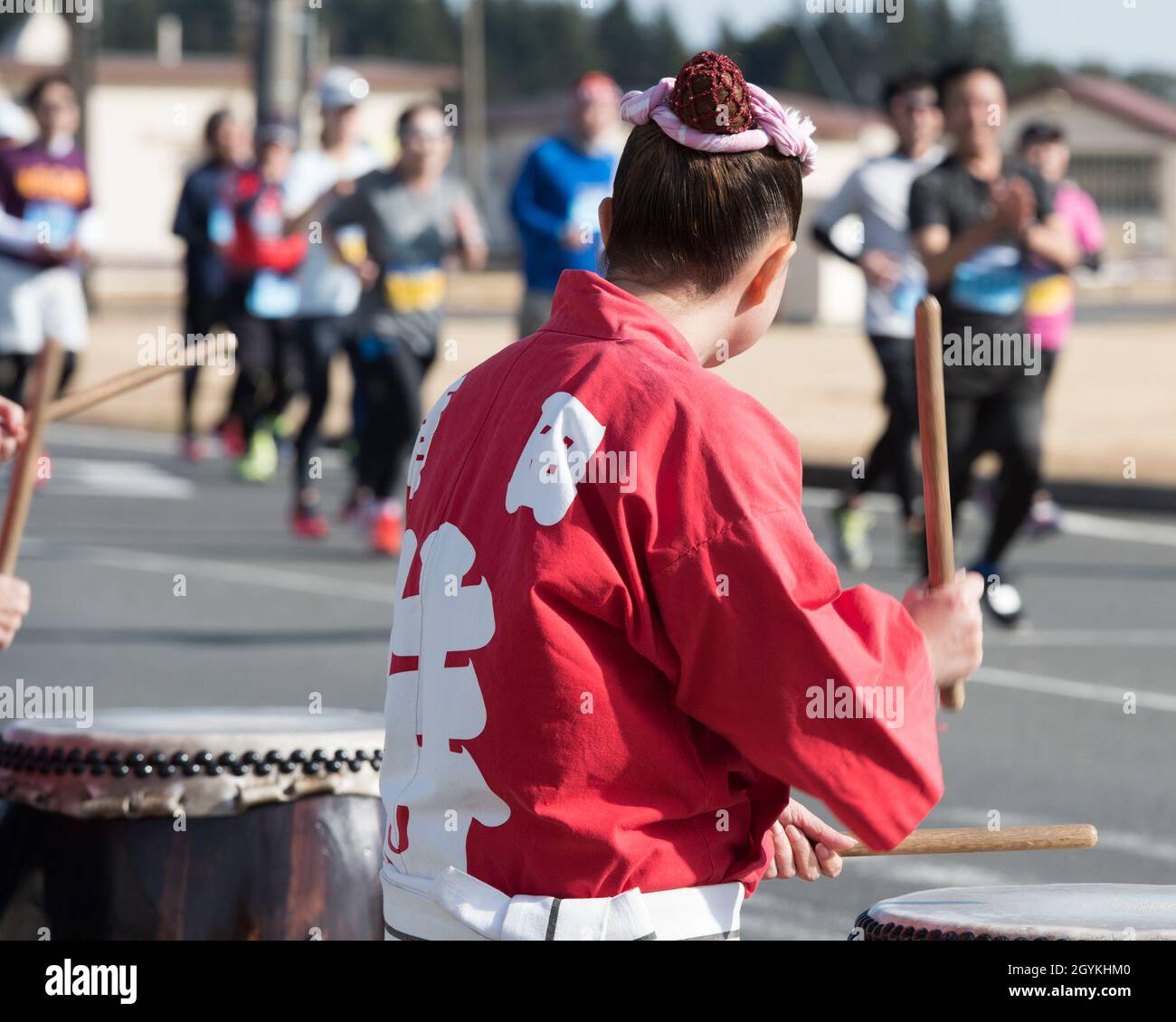 Members of the Samurai Taiko Drum Team cheer the runners during the ...
