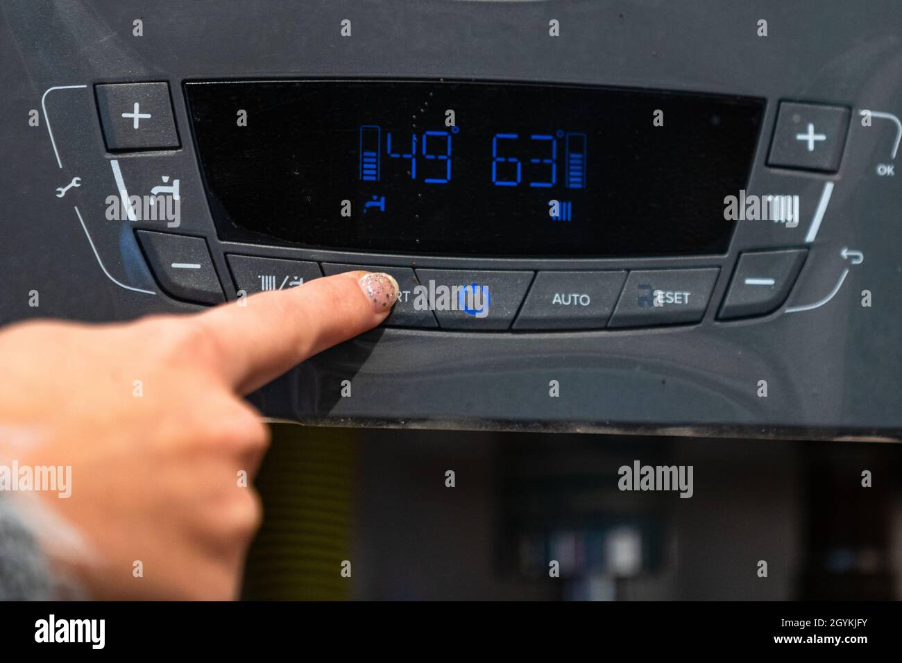 BUCHAREST, ROMANIA - Sep 01, 2021: The Girl hand setting temperature to ...