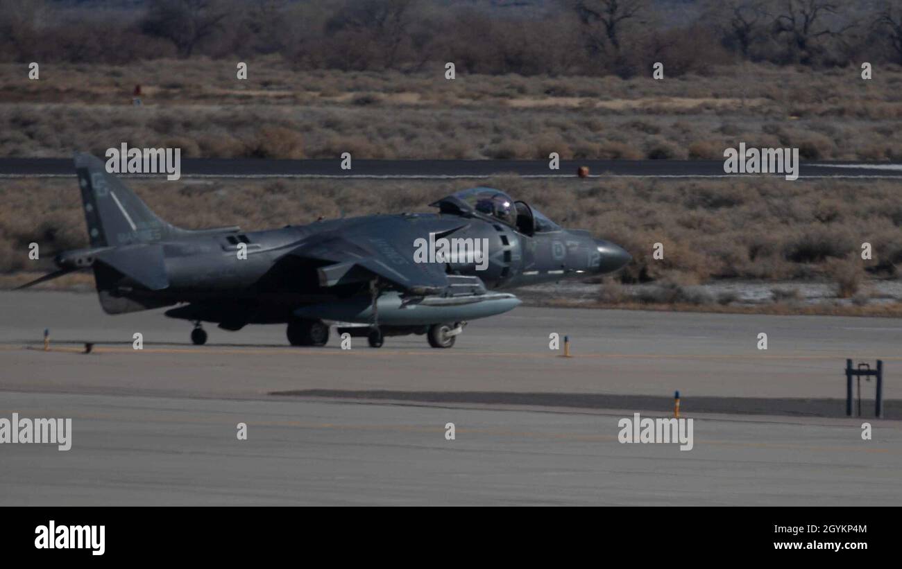 A Marine AV-8B Harrier II taxis down a runway during cold weather ...