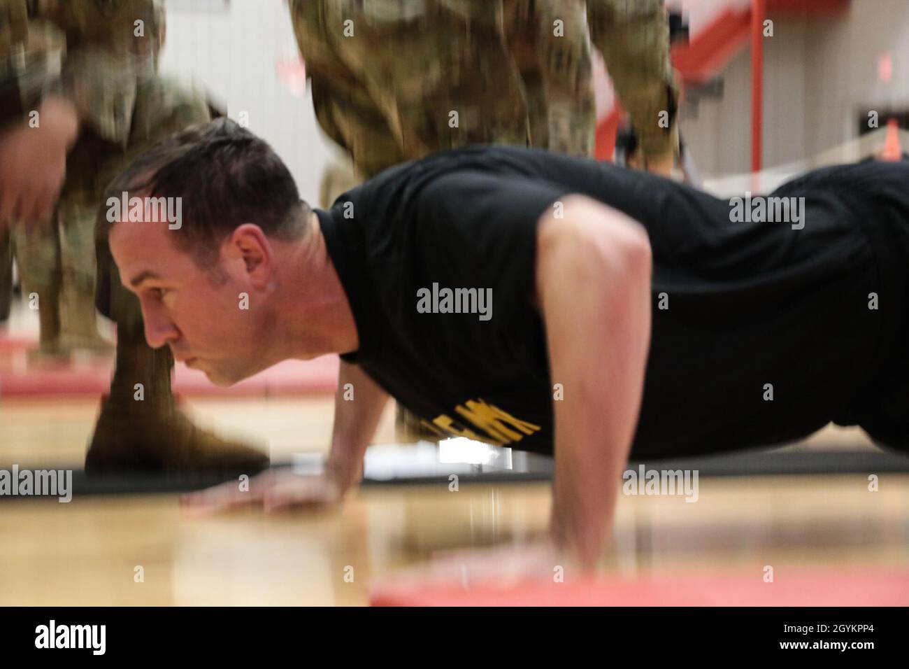 Candidates from cohort 5 perform push-ups as they take an Army Physical ...