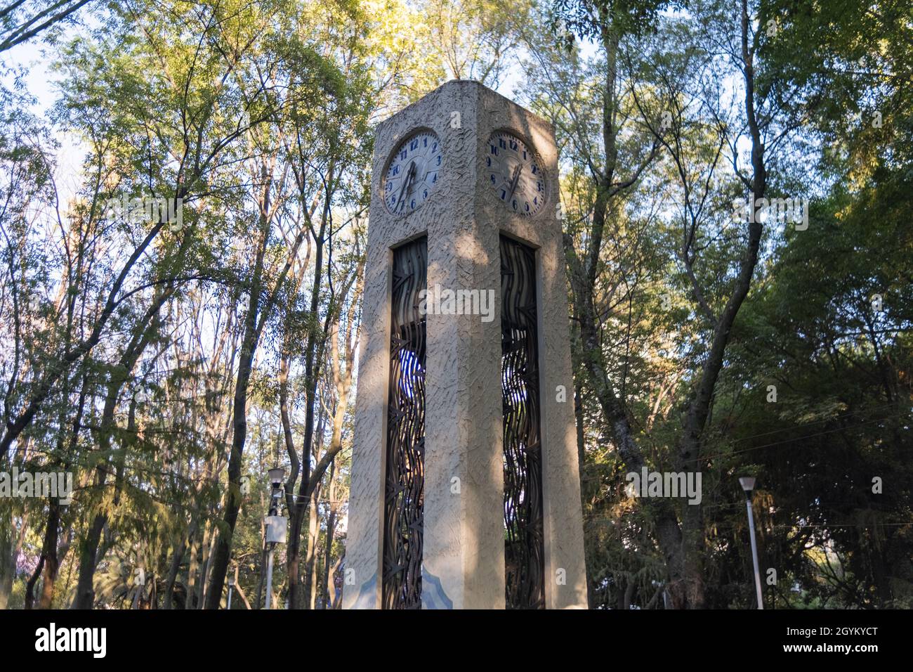 Small clock tower with trees and bright sunlight as background Stock ...
