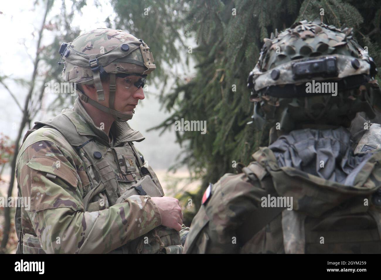 Maj. Mark Pollak, 8th Engineer Battalion, 2nd Brigade Combat Team works with a member of the ...