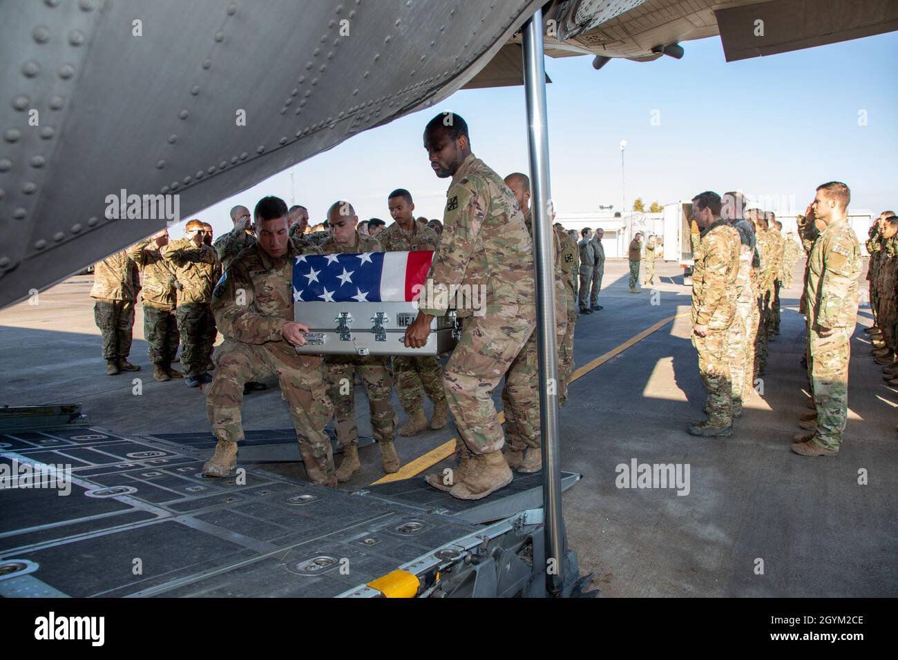 U.S. Soldiers carry a flag-draped transfer case holding the remains of ...
