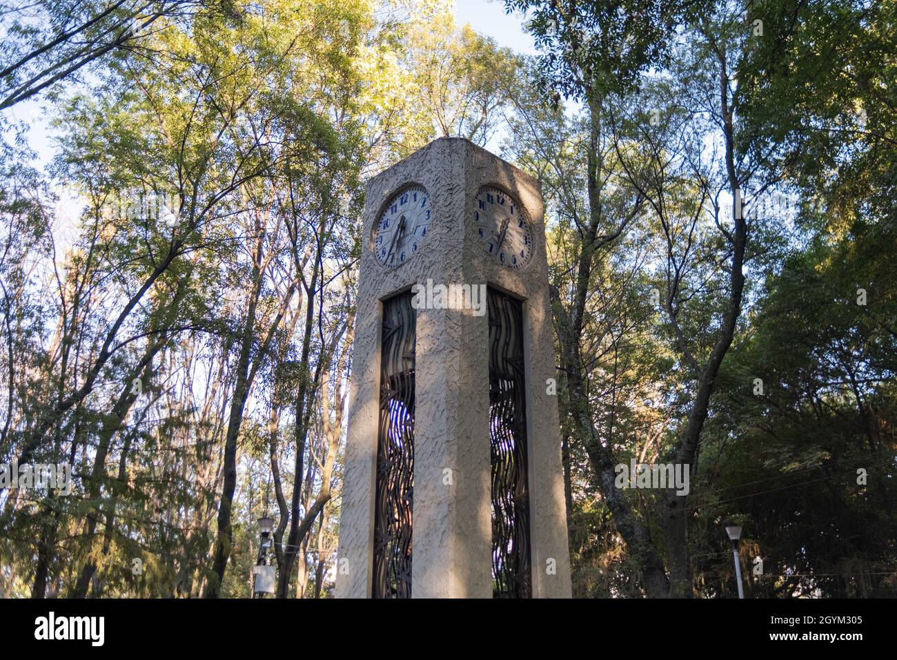 Small clock tower with trees and bright sunlight as background Stock ...