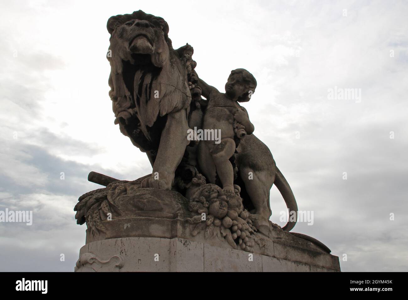 statue of a lion and a child at the alexandre III bridge in paris ...