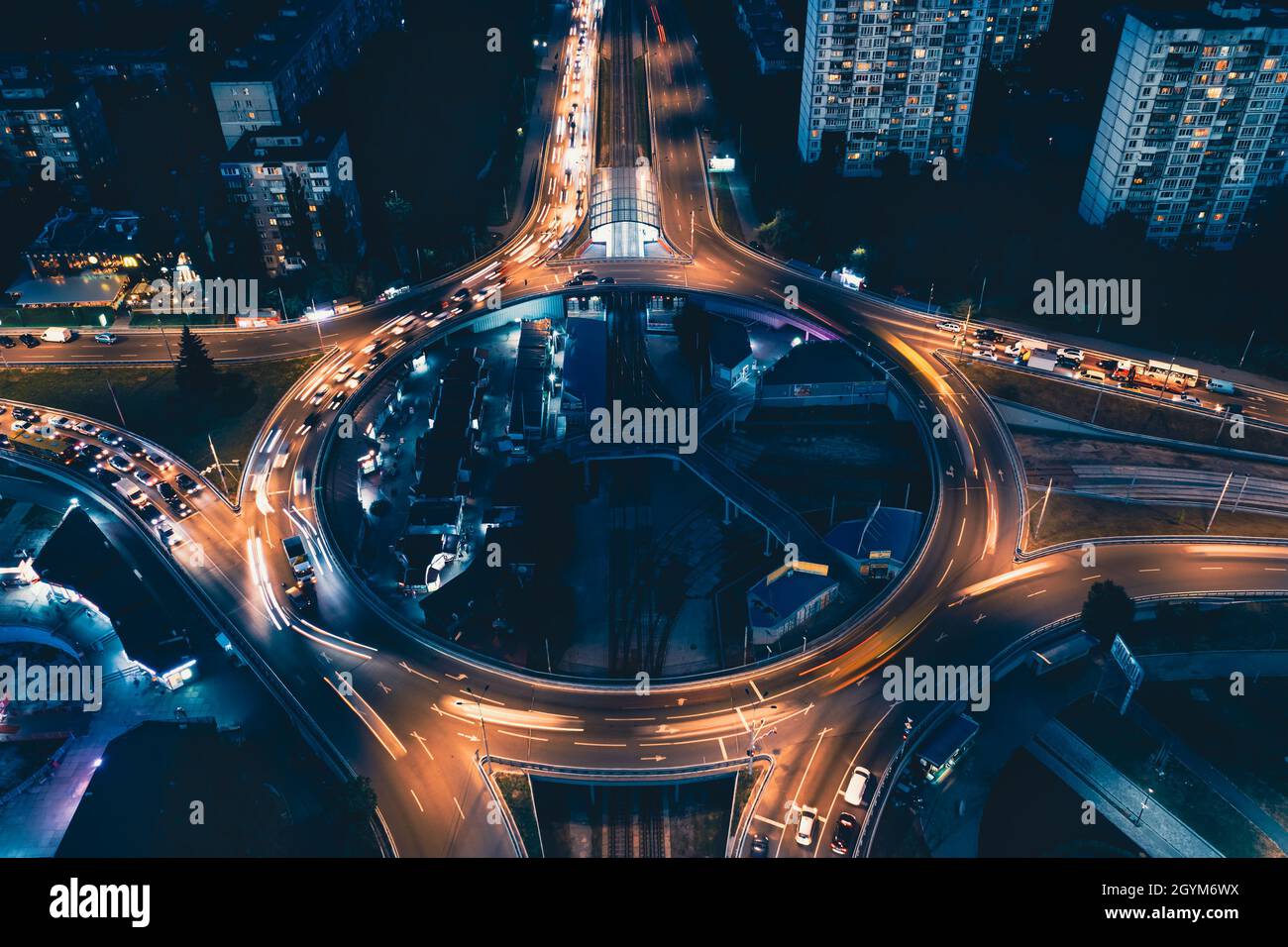 Night lights from car headlights on roundabout in night city. Traces of ...