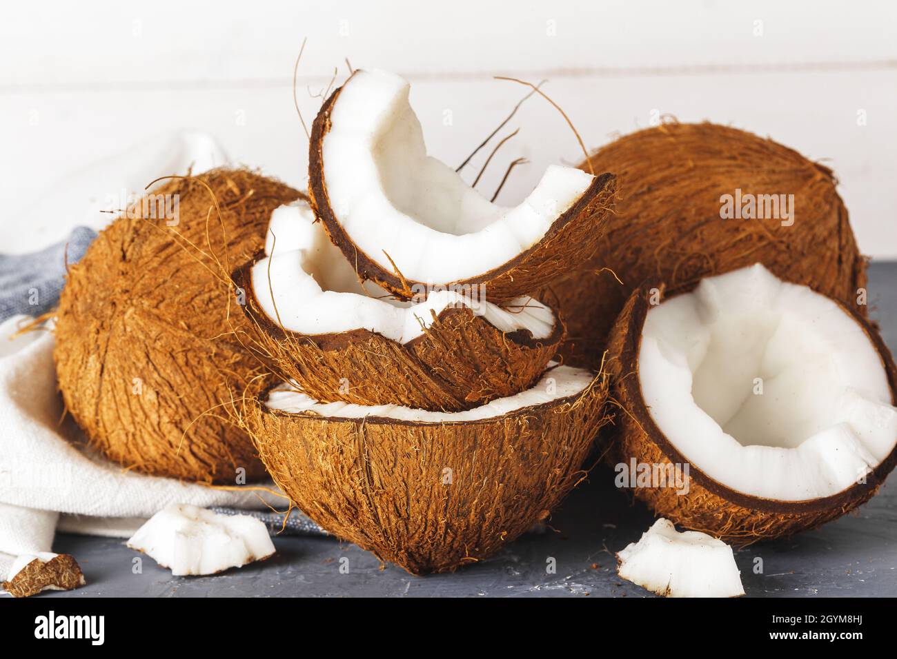 Pile of broken coconuts on ripped grey background Stock Photo - Alamy
