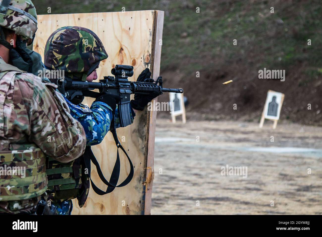 Members of the Romanian armed forces conduct marksmanship training with ...