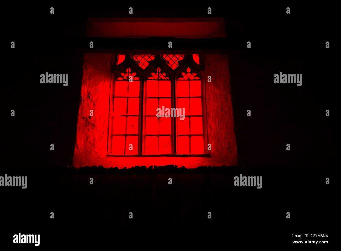 A horror concept of a spooky church window. With a red, black moody ...
