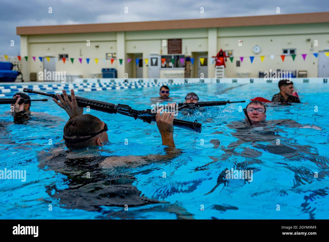 U.S. Marines and sailors hold their rifles above water during a water ...