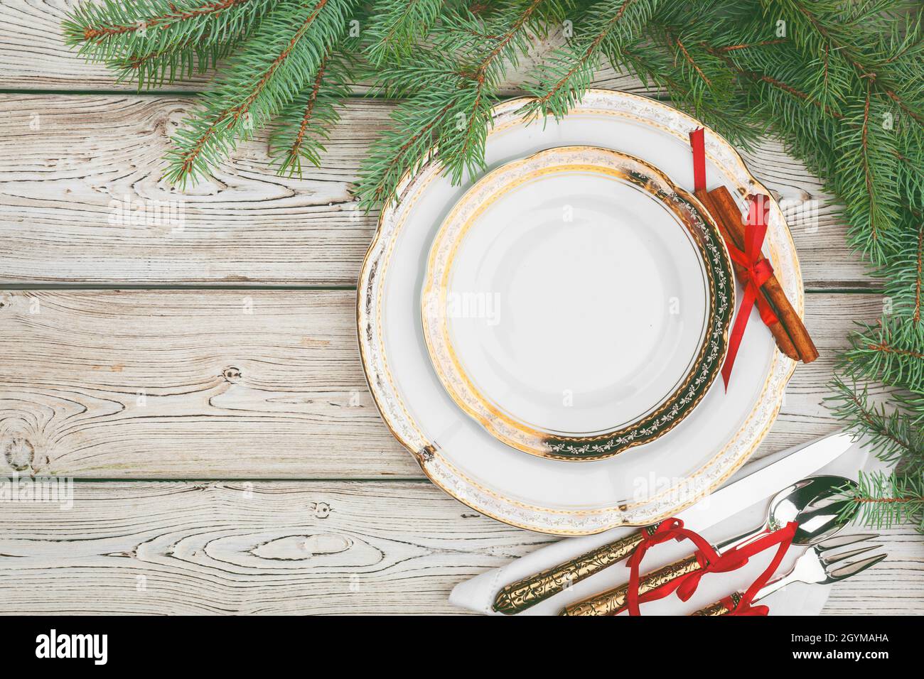 Wooden table with pine tree branches and holiday table setting Stock ...