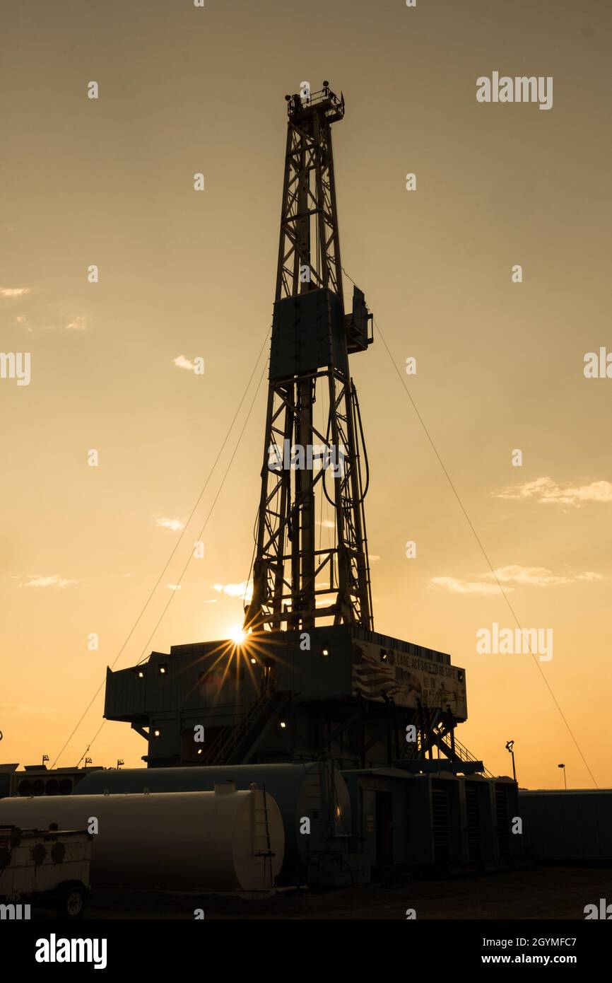 Sunset behind a 3000 hp top drive drilling rig drilling for oil in the ...