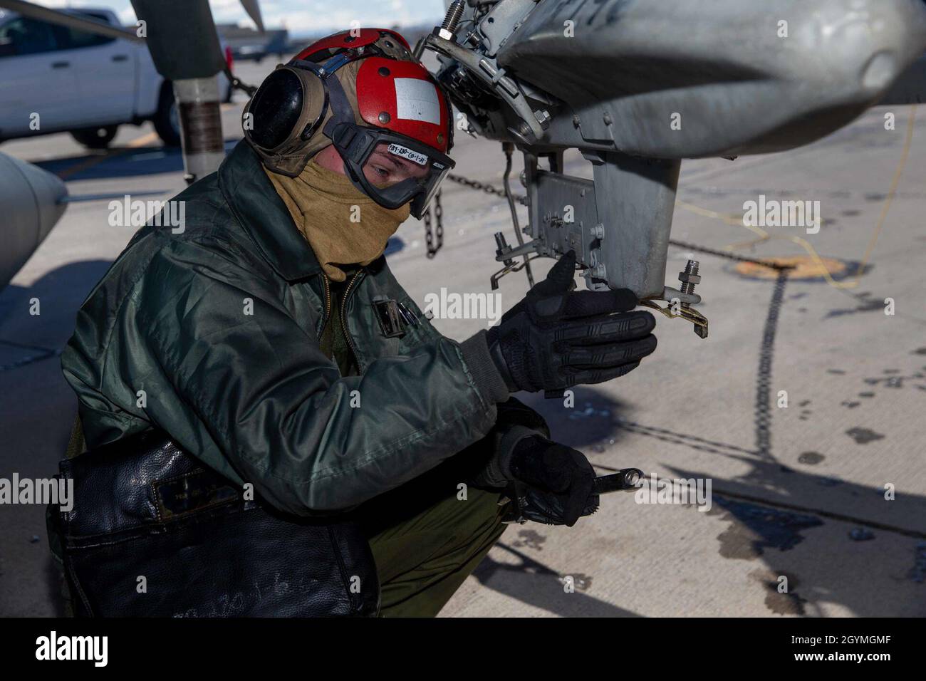 Lance Cpl. Stephen Huesken loosens a bolt on a bomb rack during cold ...
