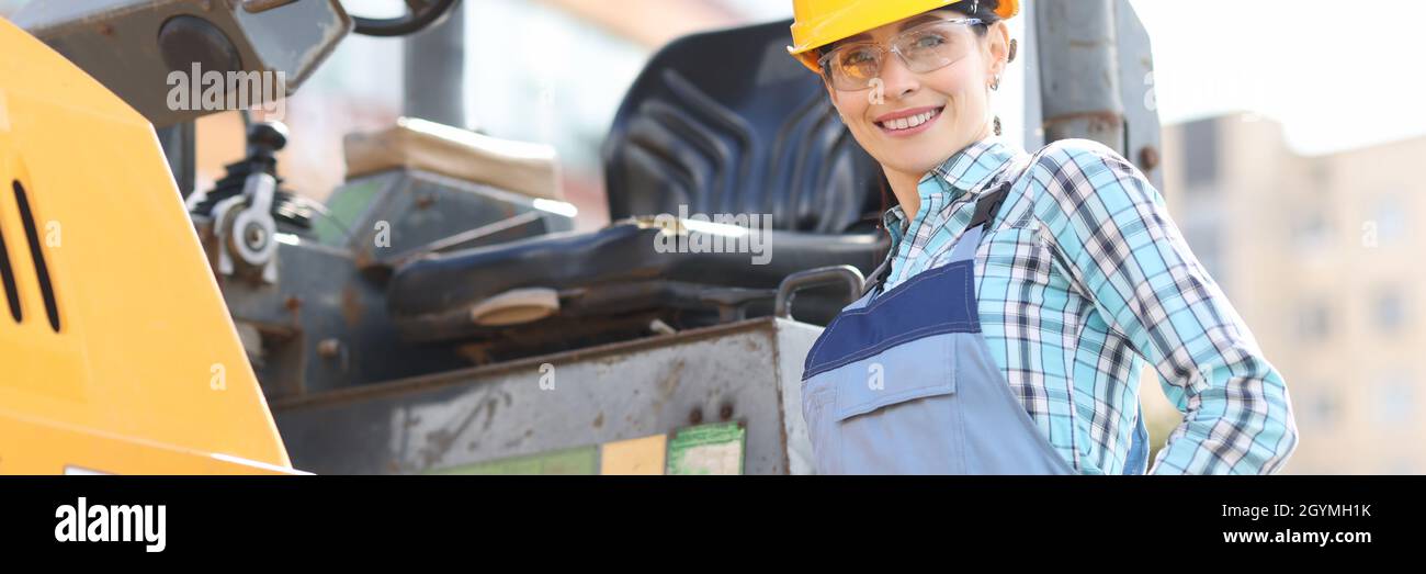 Portrait of smiling female foreman in helmet with documents and pen on ...