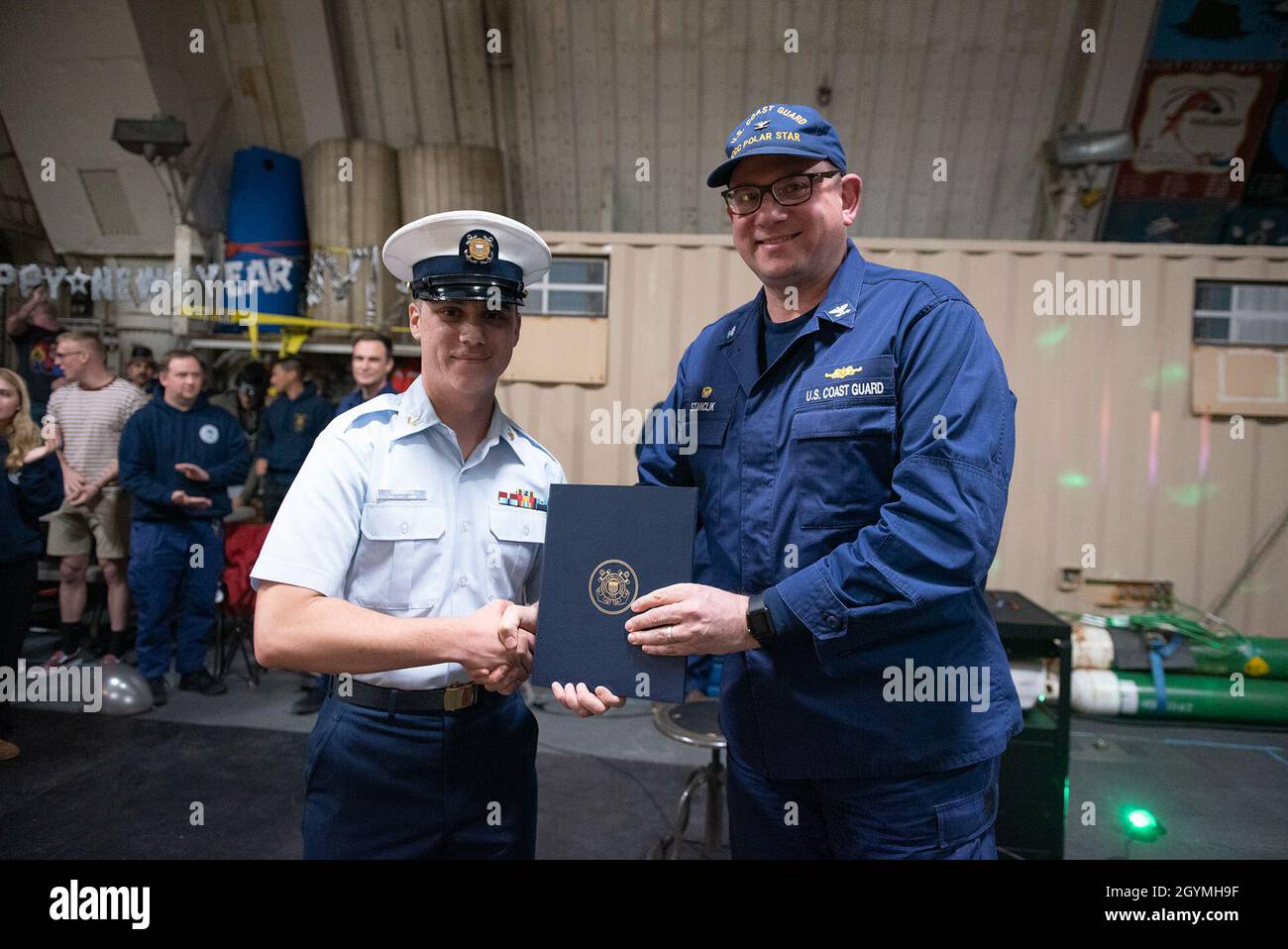 U.S. Coast Guard Capt. Greg Stanclik (right) presents Petty Officer 2nd ...