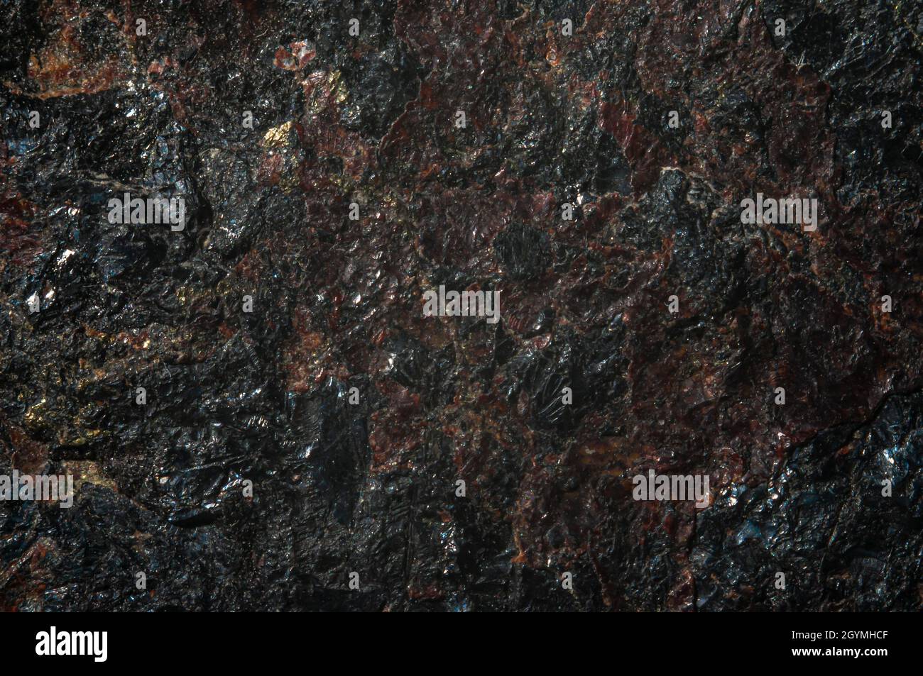 Textured surface of dark natural stone with various inclusions ...