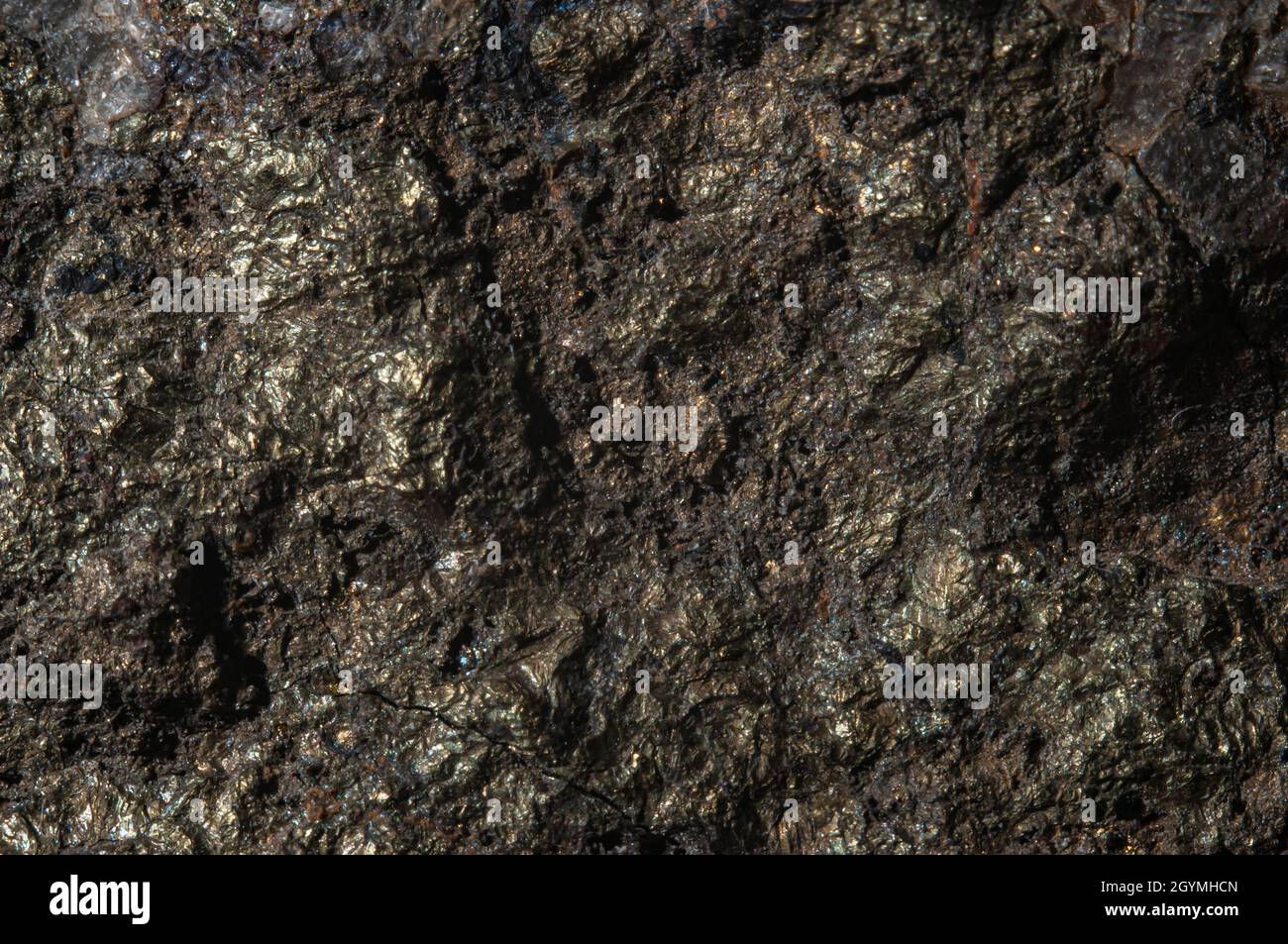 Textured surface of dark natural stone with various inclusions ...