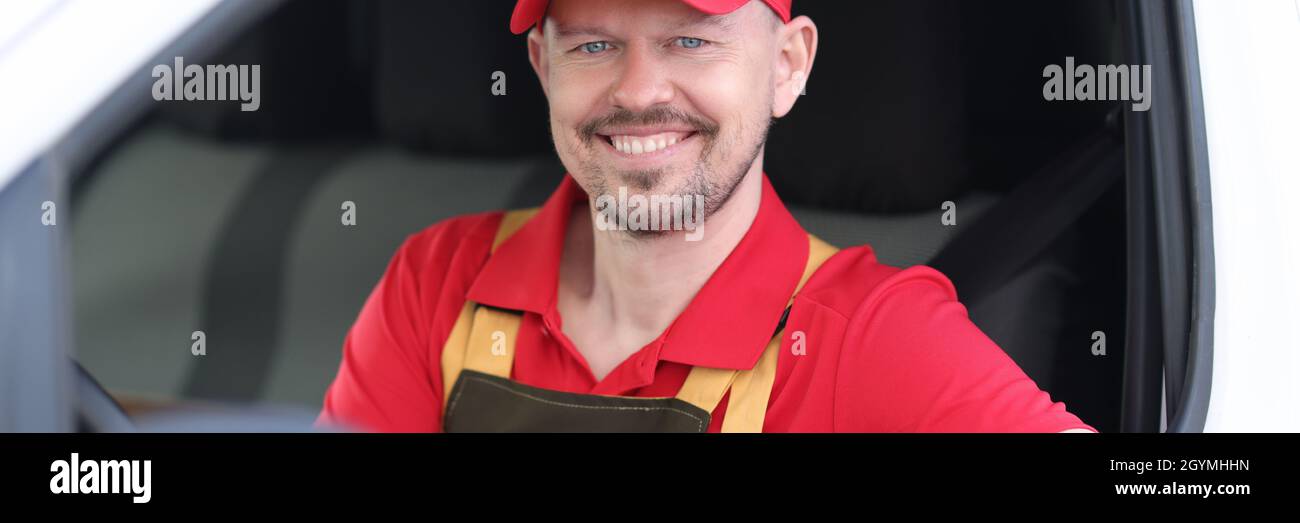 Smiling portrait of male courier driver holding documents in car window ...