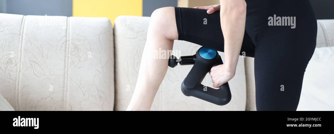 Woman makes massage with percussion massager of lower leg Stock Photo ...