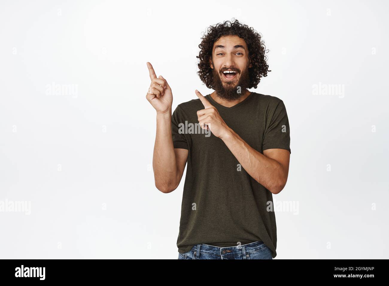 Advertising. Smiling handsome man pointing at upper left corner ...