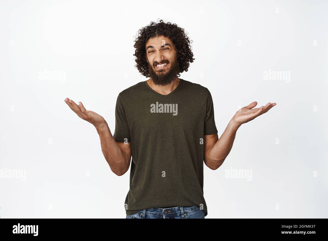 Confused middle eastern man shrugging shoulders, looking indecisive and ...