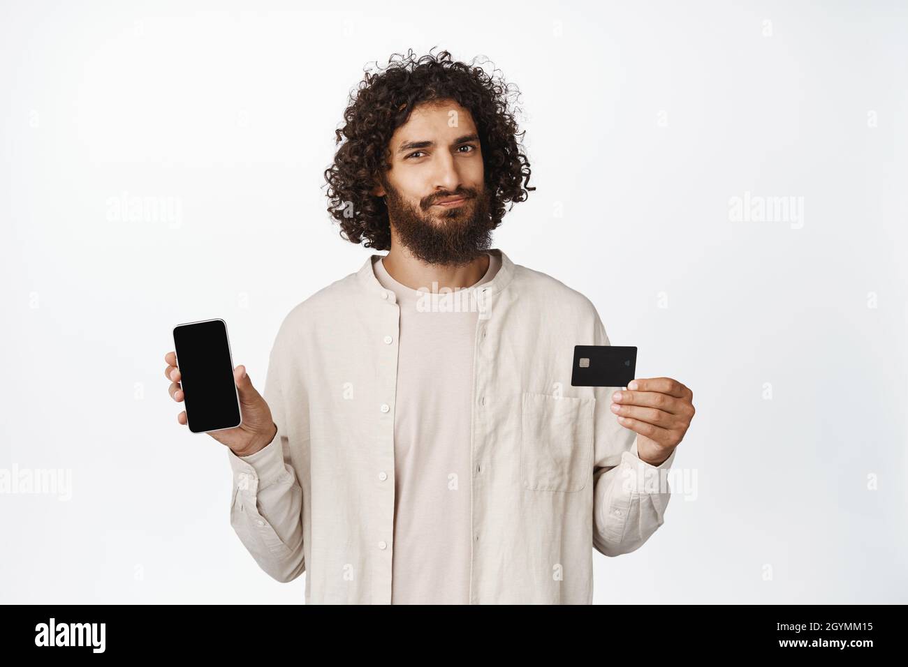 Disappointed young man showing mobile phone screen and credit card ...