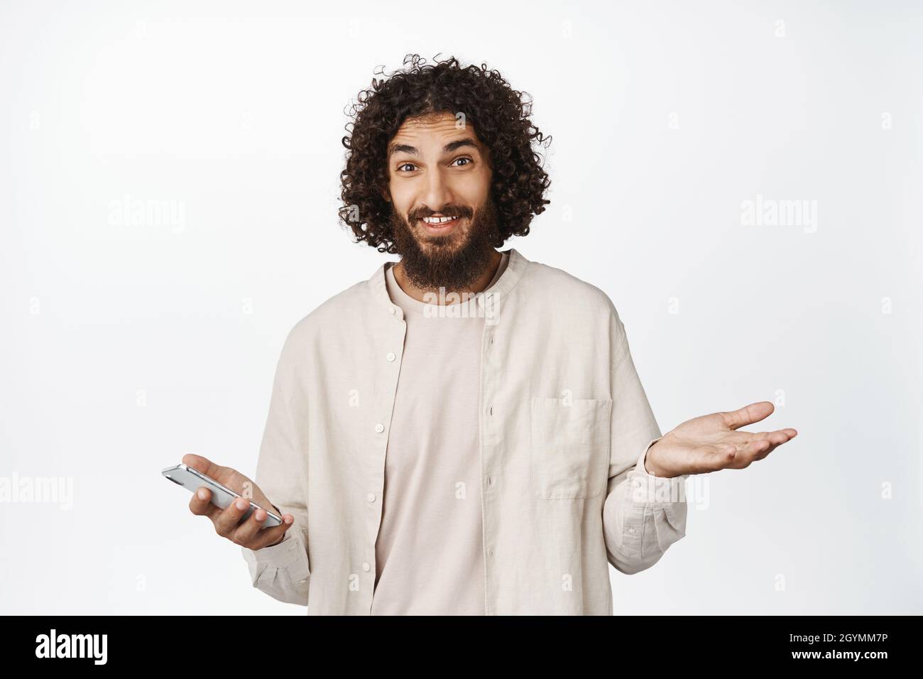 Oops sorry. Smiling guilty guy shrugging shoulders and holding ...