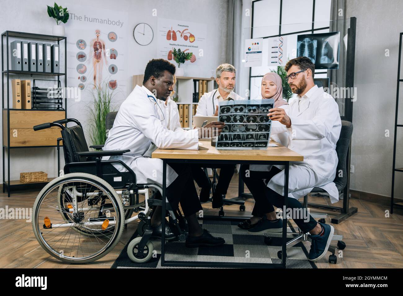 Multicultural male and female doctors sitting together at office desk ...
