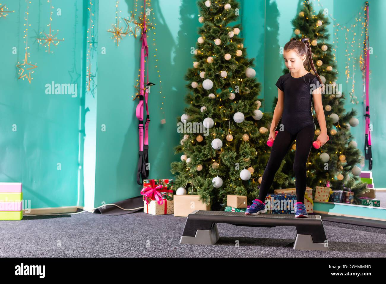 Merry Christmas and a happy new year. Little girl workout at home in ...