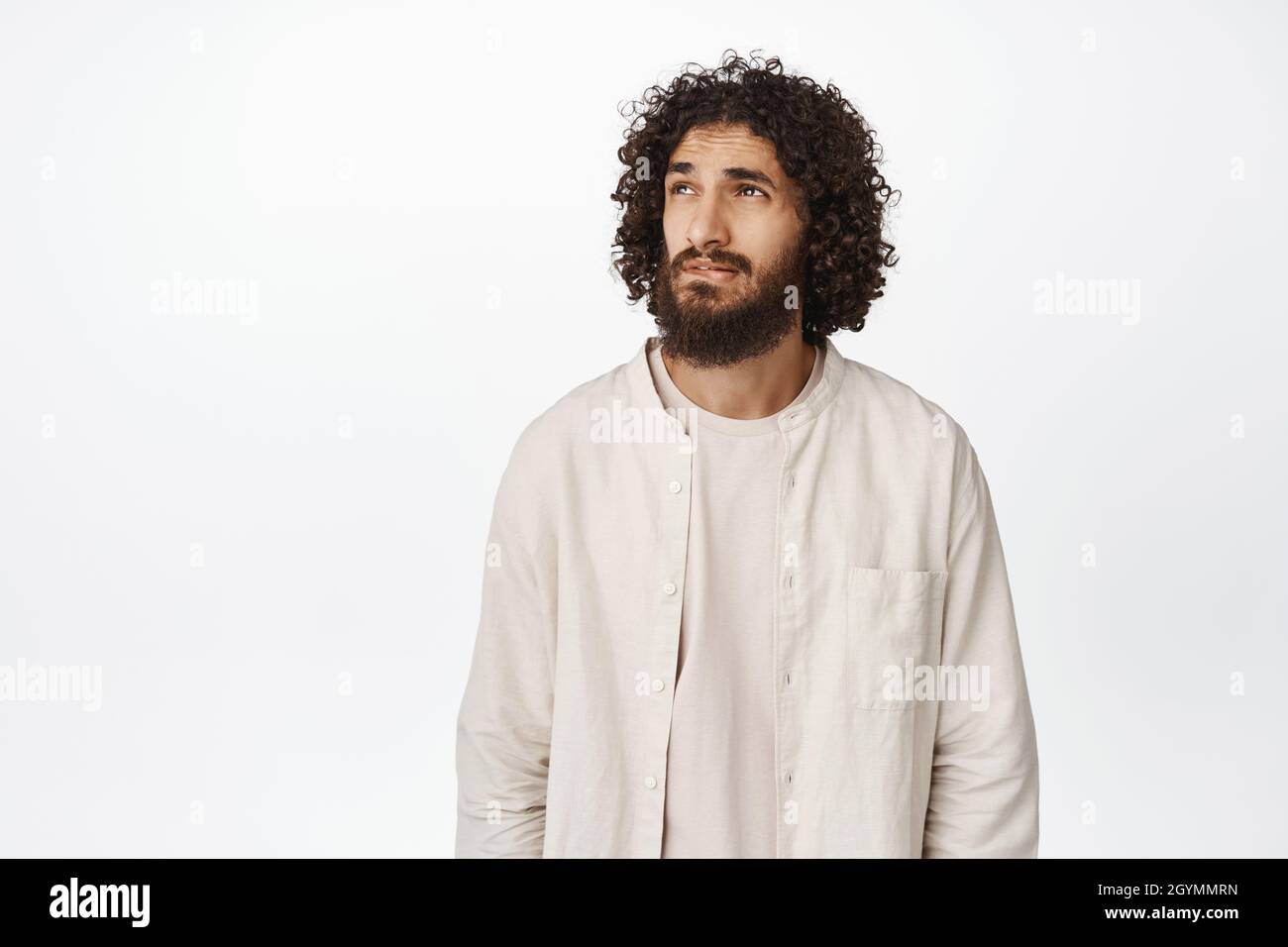 Portrait of thoughtful middle eastern man looking at upper left corner ...