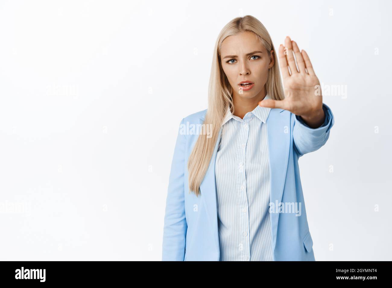 Serious young businesswoman stretch out hand and showing stop, deny ...