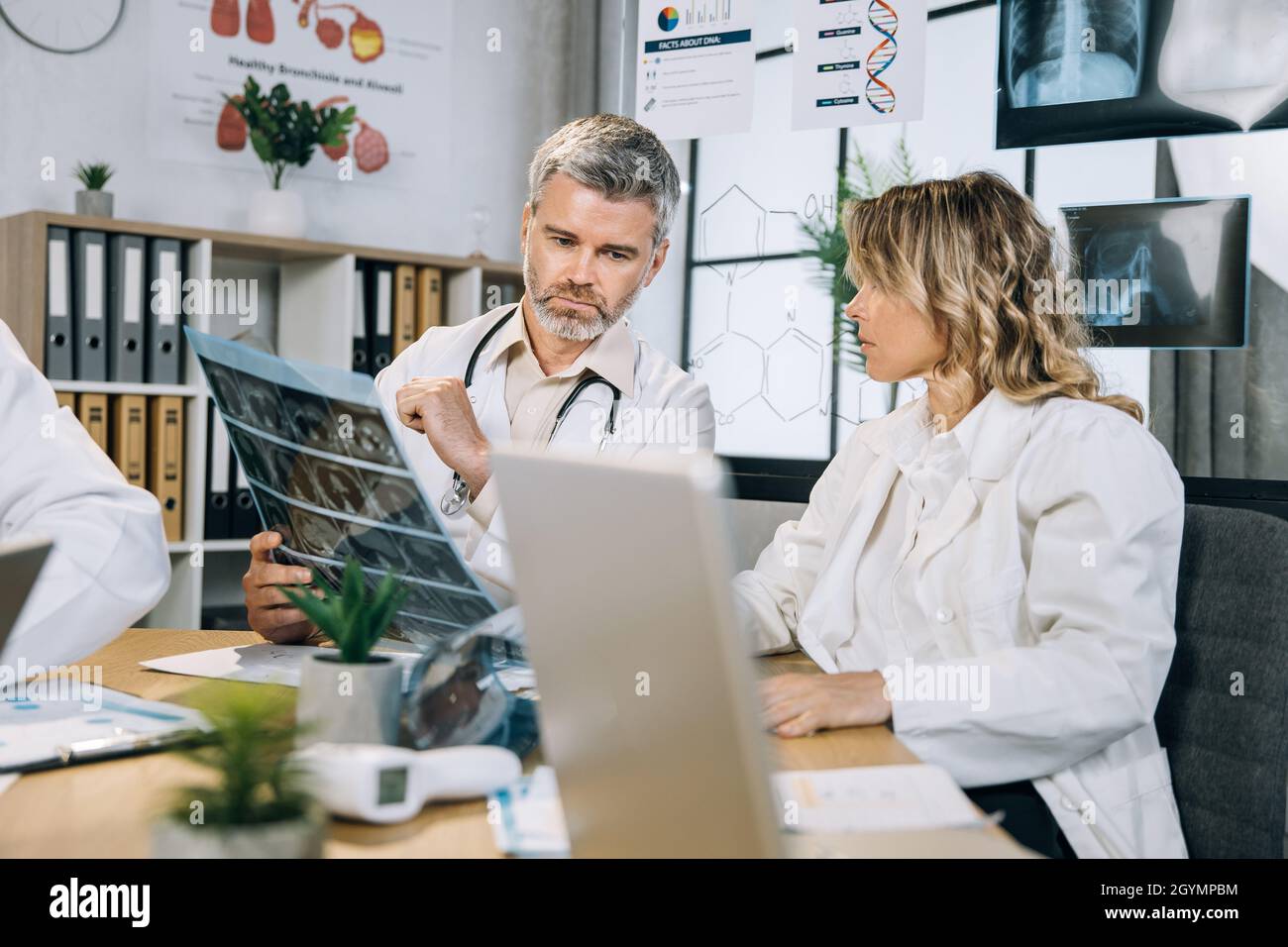 Two focused medical workers using modern gadgets while examining ...