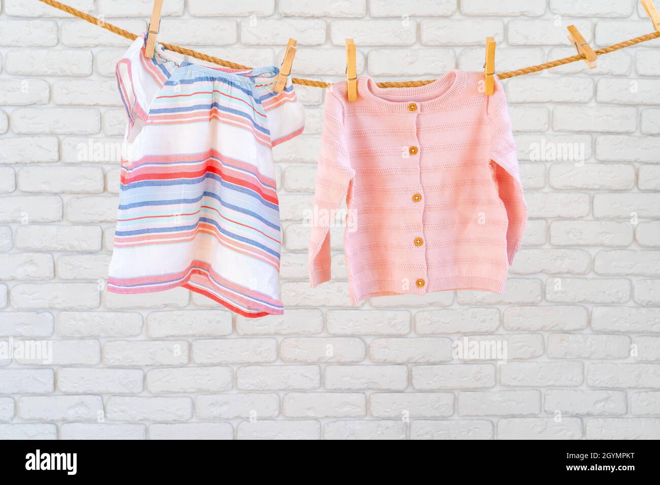 Washing of baby clothes pinned on a rope to dry Stock Photo - Alamy
