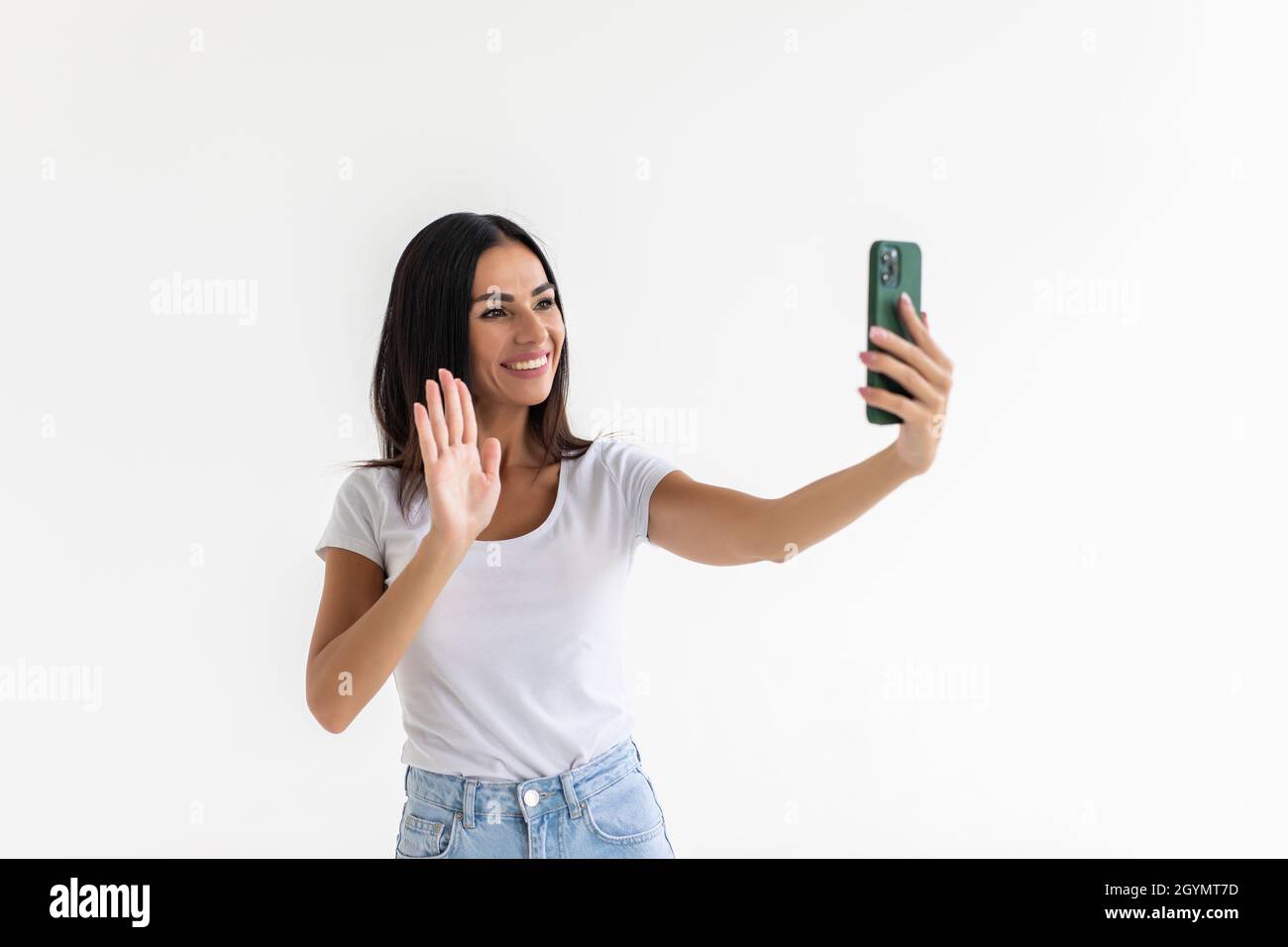 Smiling young womanmaking selfie photo while waving palm isolated on a ...