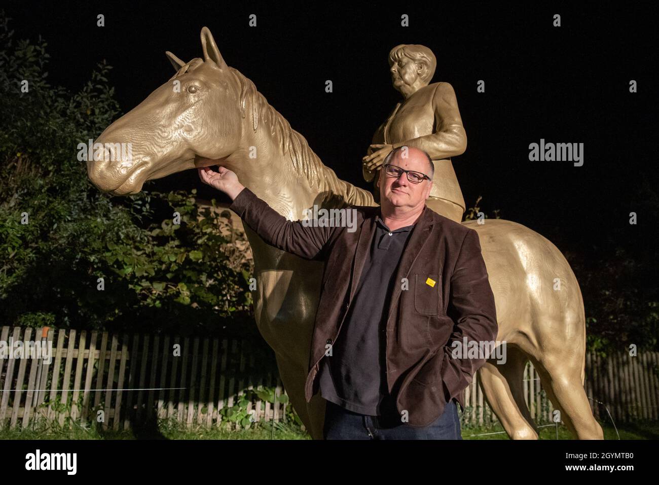 Etsdorf, Germany. 08th Oct, 2021. Artist Wilhelm Koch stands next to an ...