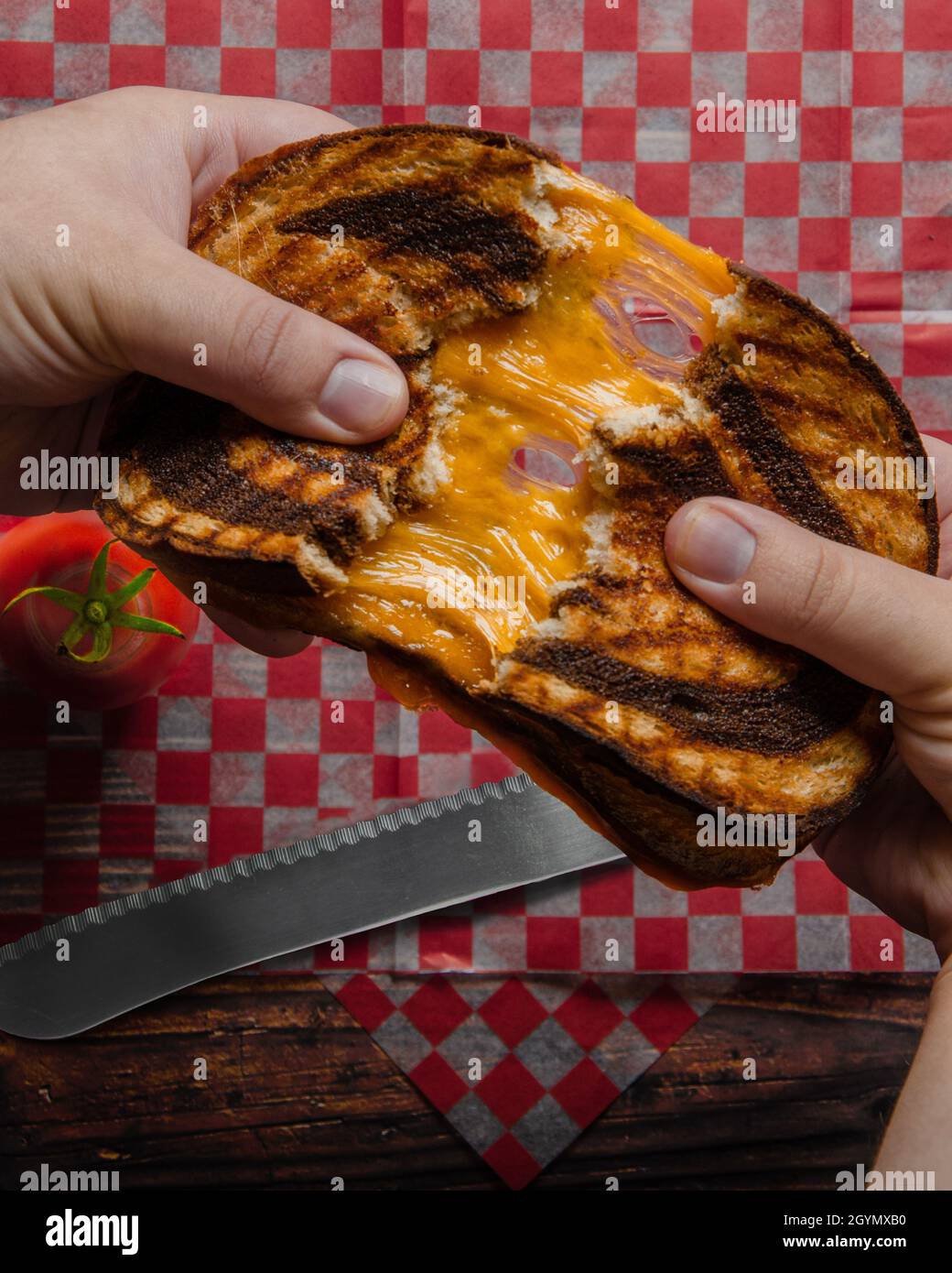 Hands Pull Apart Grilled Cheese Sandwich with Tomato and Knife on ...