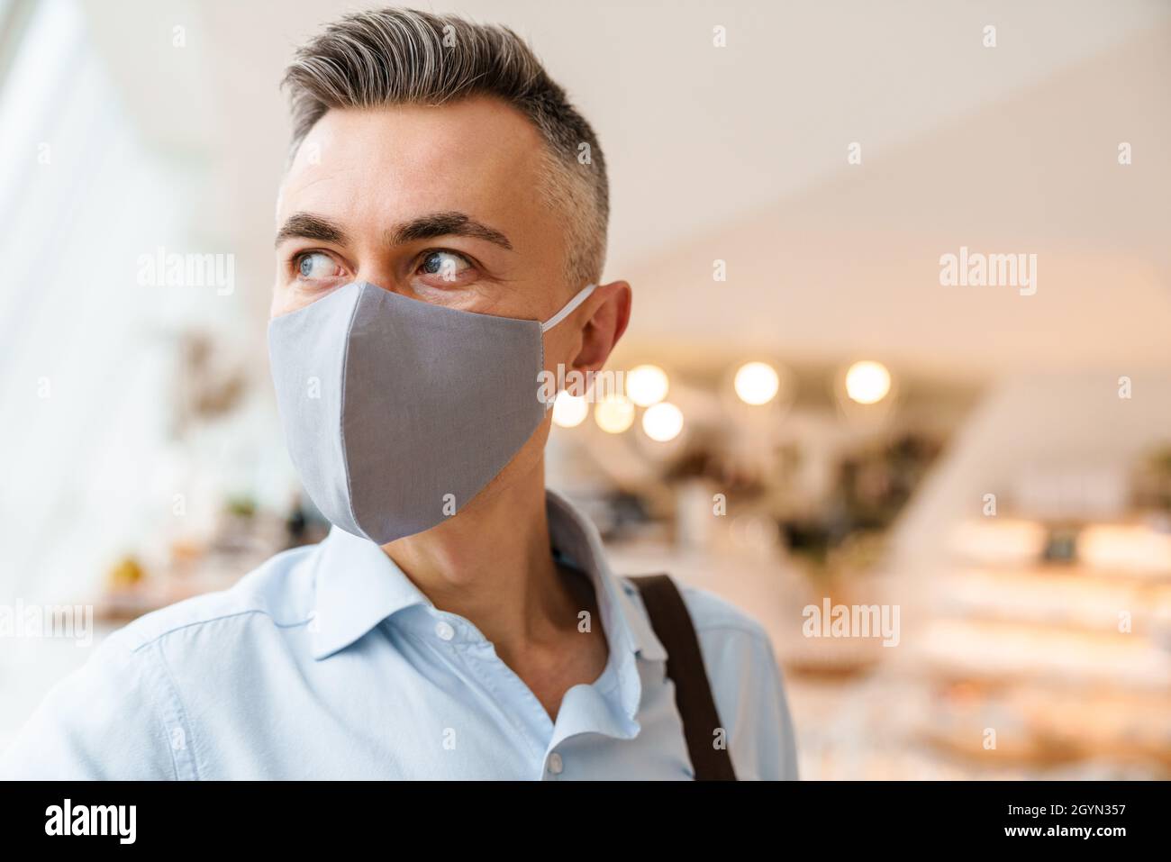 Close up of a confident businessman wearing medical face mask indoors ...