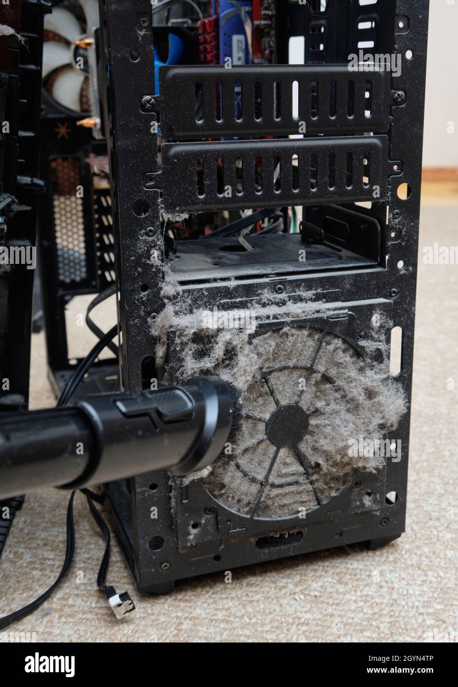 Cleaning the system unit of a desktop computer from dust with a vacuum ...