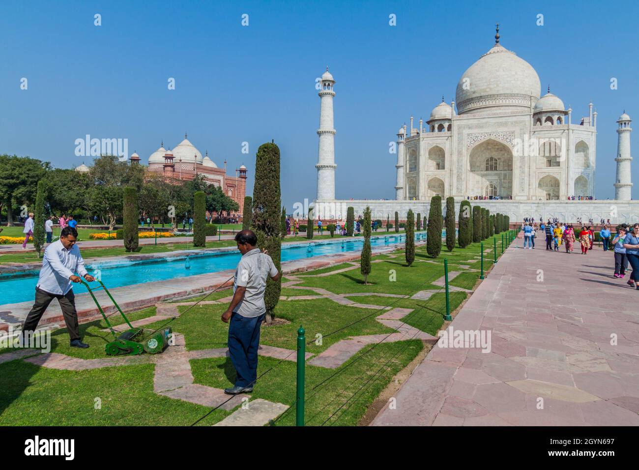 AGRA, INDIA - FEBRUARY 19, 2017: Local gardeners mowe a lawn on grounds ...