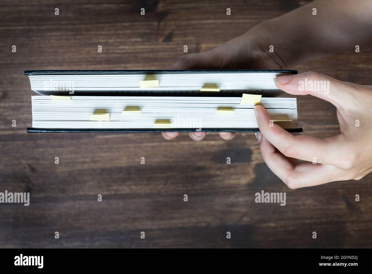 a closed book in a woman's hands Stock Photo - Alamy