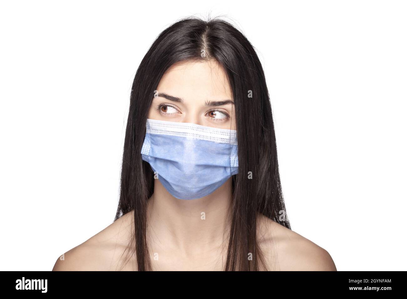 Portrait of a brunette girl wearing medical mask over her mouth and ...