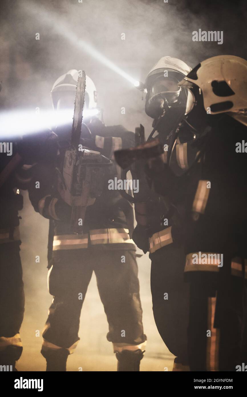 Group of professional firefighters wearing full equipment, oxygen masks ...