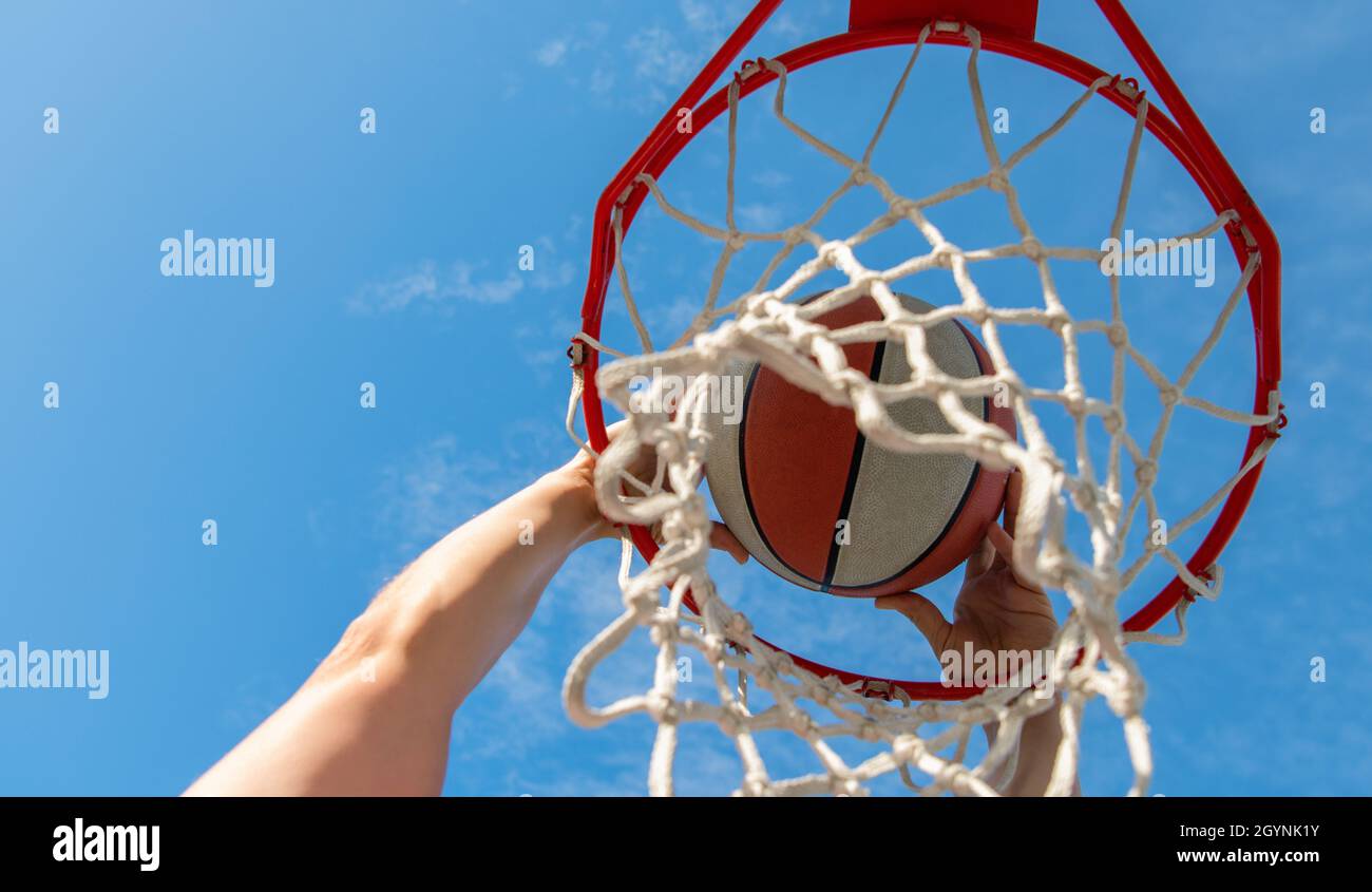 man dunking basketball ball through net ring with hands, sport Stock ...