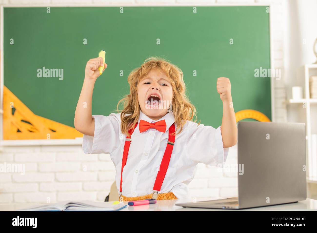 shouting kid boy in bow tie study in school classrrom at blackboard ...