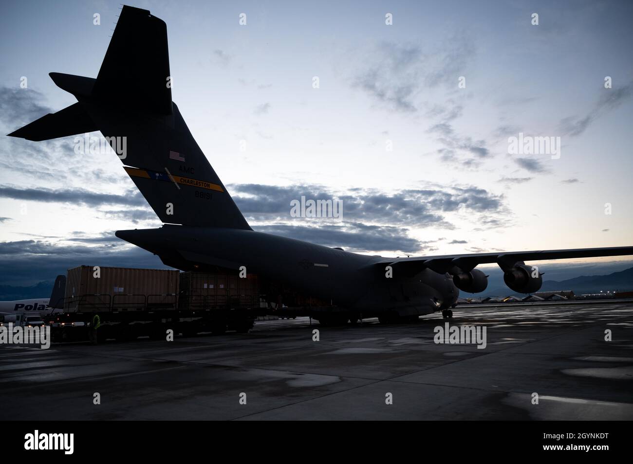 U.S. Air Force Airmen and contractors load cargo aboard a U.S. Air ...